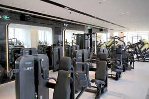 Uma academia com diversos equipamentos de exercício, incluindo aparelhos de musculação e esteiras.