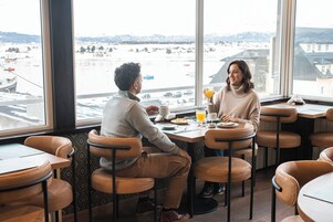 Um casal jantando em um restaurante com vista para uma paisagem nevada.
