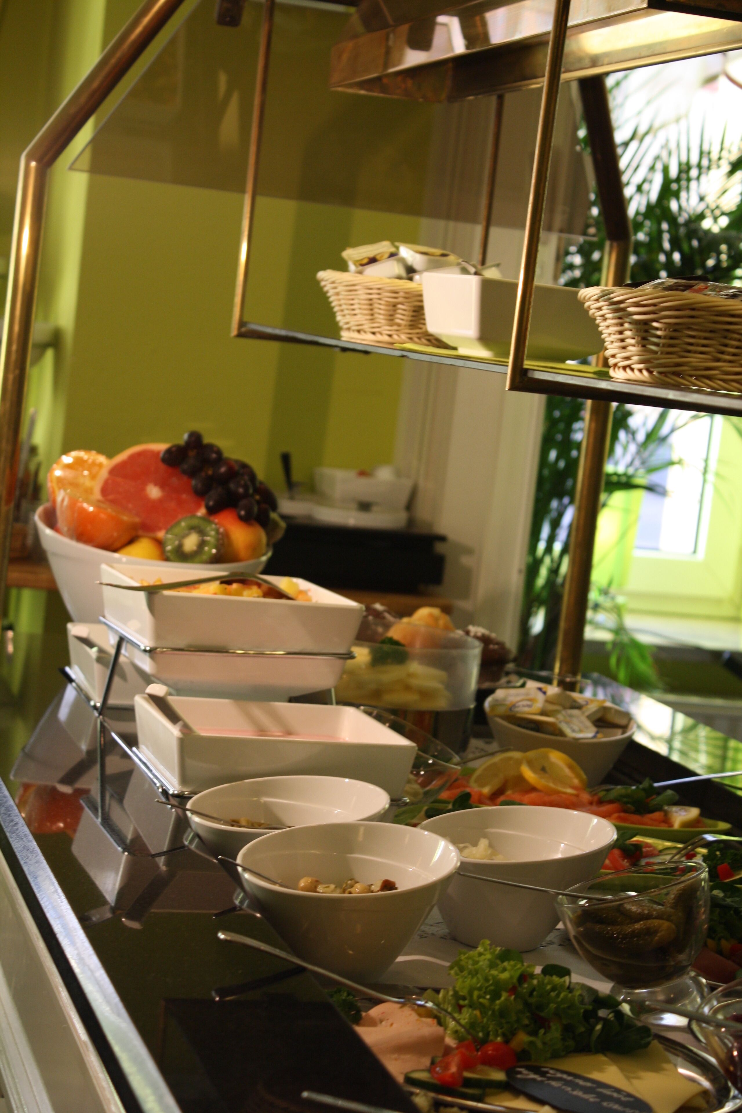Disposição de buffet com diversos alimentos e recipientes em uma mesa.