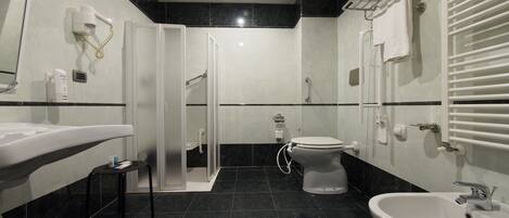 Uma casa de banho moderna com uma grande pia, bidé, sanita e chuveiro para bidé.