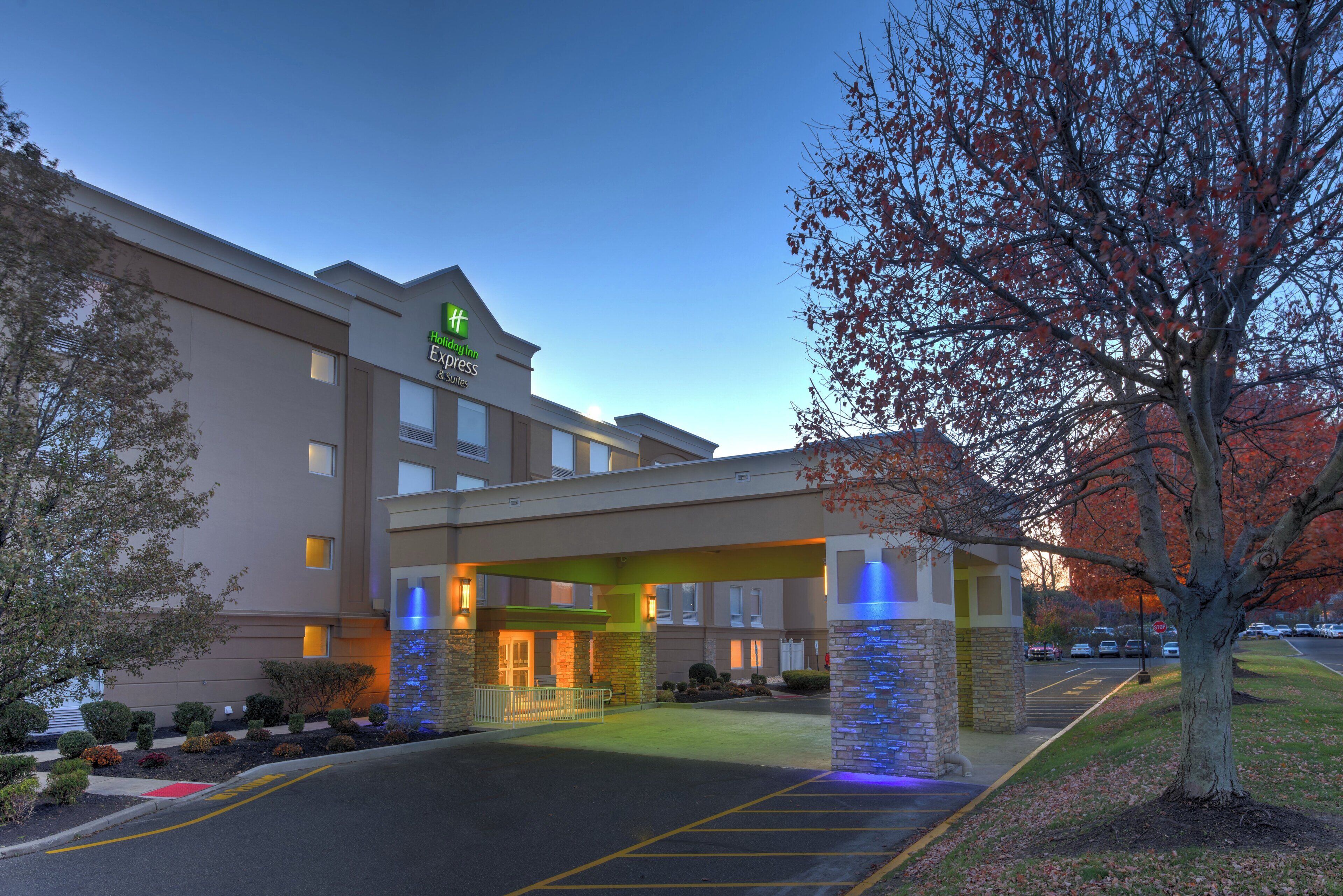 Um hotel Holiday Inn Express com fachada moderna, entrada coberta e estacionamento.