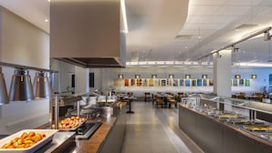 Uma moderna disposição de buffet com várias estações de comida e áreas de estar.