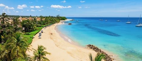 Na praia, espreguiçadeiras, guarda-sóis de praia, toalhas de praia