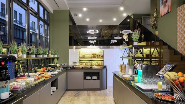 Cozinha moderna com serviço de buffet, apresentando diversas opções de comida e um espaço para café.