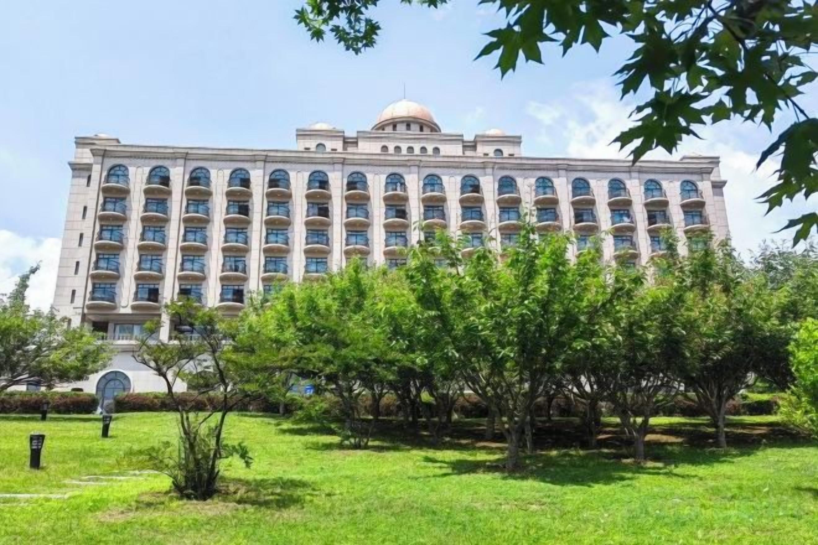 Um hotel grande com fachada simétrica, várias varandas e uma cúpula central.
