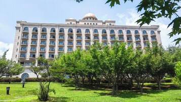 Um hotel grande com fachada simétrica, várias varandas e uma cúpula central.