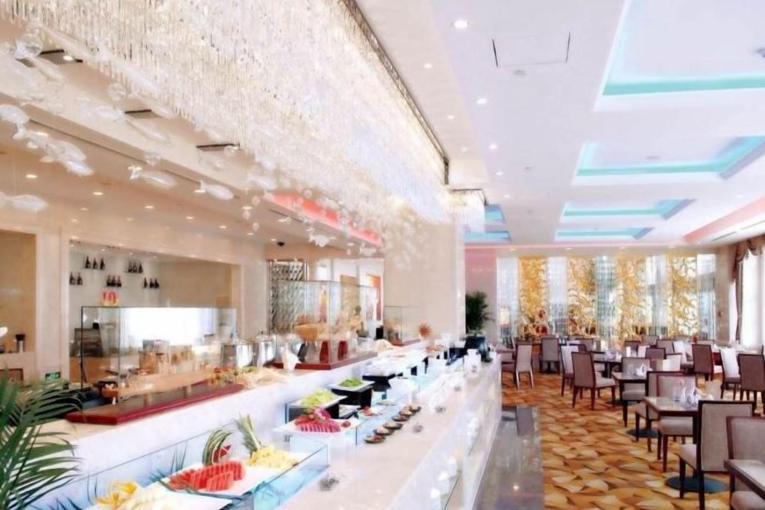 Um saguão de hotel com um balcão de recepção extenso, área de estar e buffet.