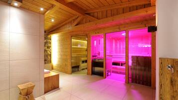 Interior em madeira com parede de pedra, um banco e um ambiente iluminado em rosa.