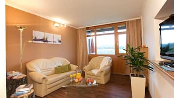 Suíte júnior, 1 quarto | Área de estar | TV