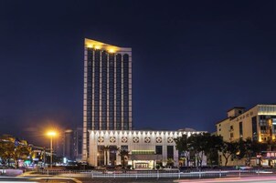 Um edifício alto com design moderno, destacando uma estrutura vertical imponente e uma fileira de janelas.