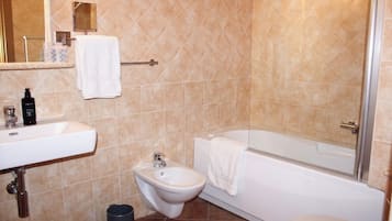 Casa de banho com lavatório, bidé, sanita e banheira.
