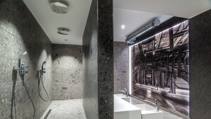 Uma casa de banho moderna com uma pia grande, dois chuveiros e um espelho fixado na parede.