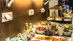Um buffet com diversos alimentos e uma escultura decorativa de coruja.