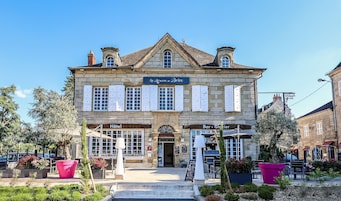 Um edifício histórico com uma placa que diz 'La Réserve de Brive' e 'Bar - Glacier', indicando um hotel e bar.
