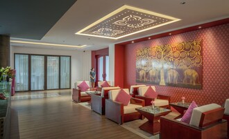 Um lobby moderno com balcão de recepção, área de estar e um grande mural na parede.