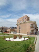 Um hotel com fachada curva e uma placa com a inscrição 'HOTEL Castilla'.