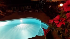 Uma área de piscina com borda curva e um arranjo floral.
