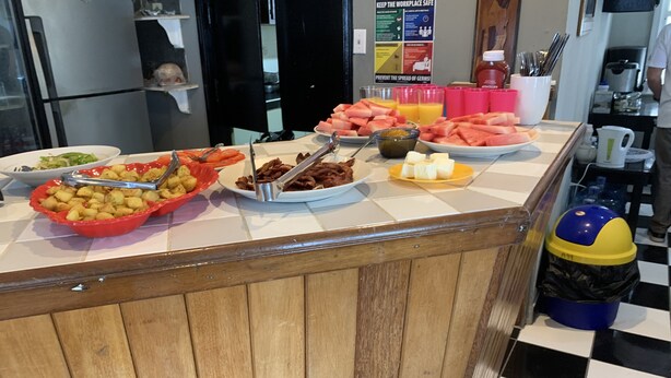 Um balcão de buffet com diversos alimentos, incluindo frutas, legumes e carnes.