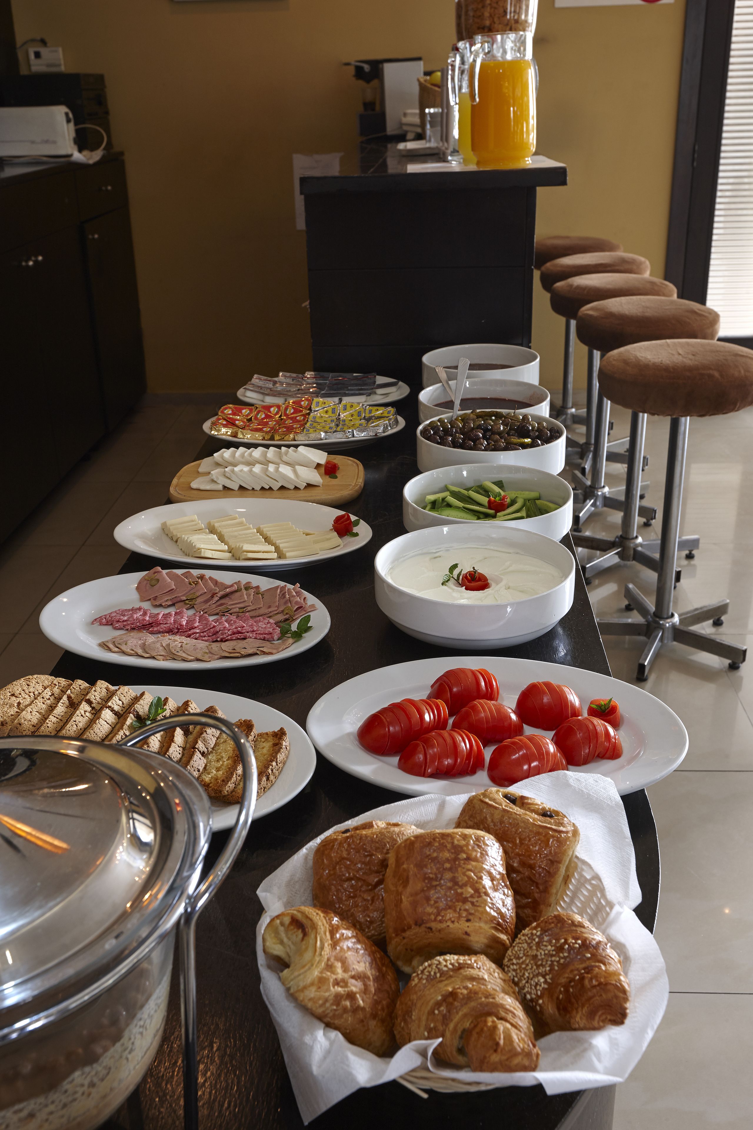 Uma mesa de buffet com diversos alimentos, incluindo pastéis, queijos e vegetais.