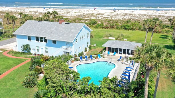 Um resort com piscina, vista para a praia e um edifício grande.