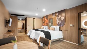 Quarto de hotel moderno com uma cama grande, uma mesa e um espaço de refeições.
