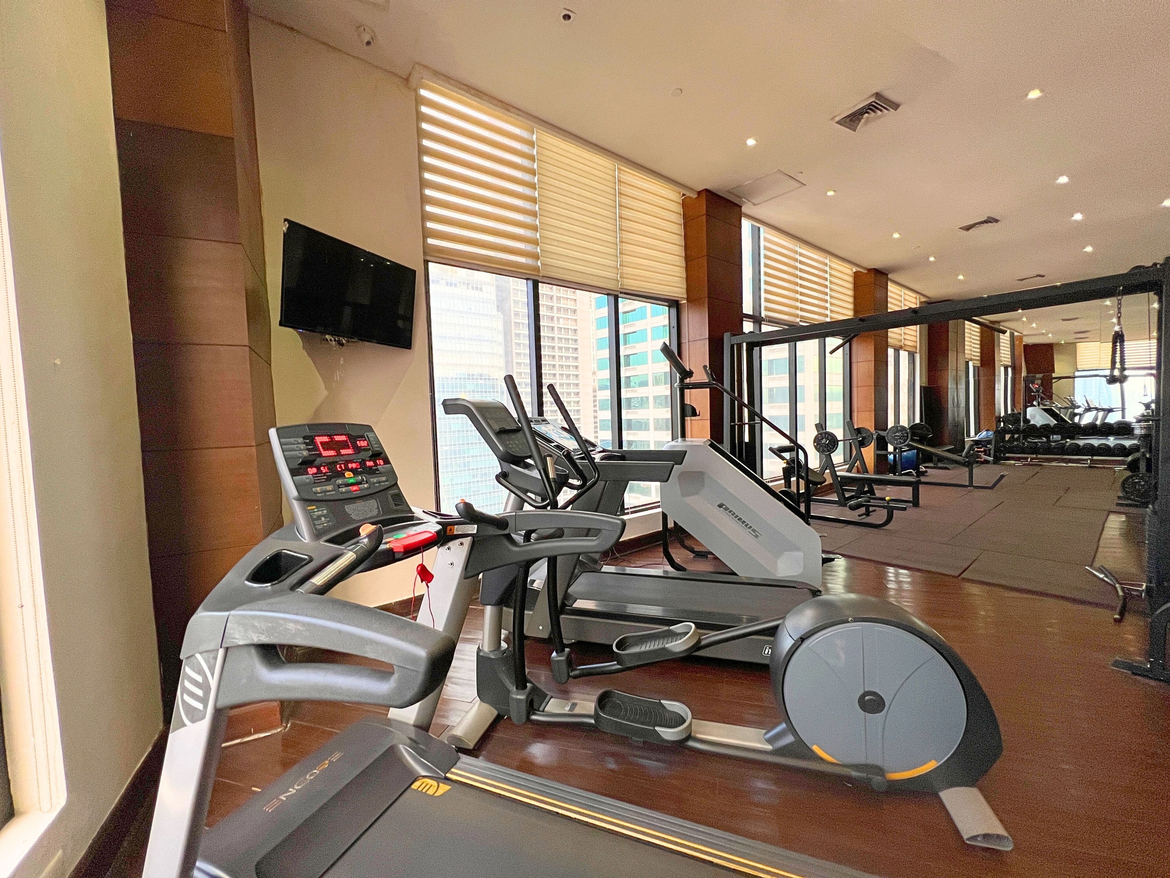 Academia com esteiras, bicicletas ergométricas e aparelhos de musculação.