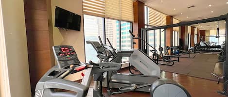 Academia com esteiras, bicicletas ergométricas e aparelhos de musculação.