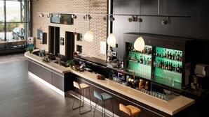 Uma área de bar moderna com parede de tijolos, banquetas e uma adega bem abastecida.