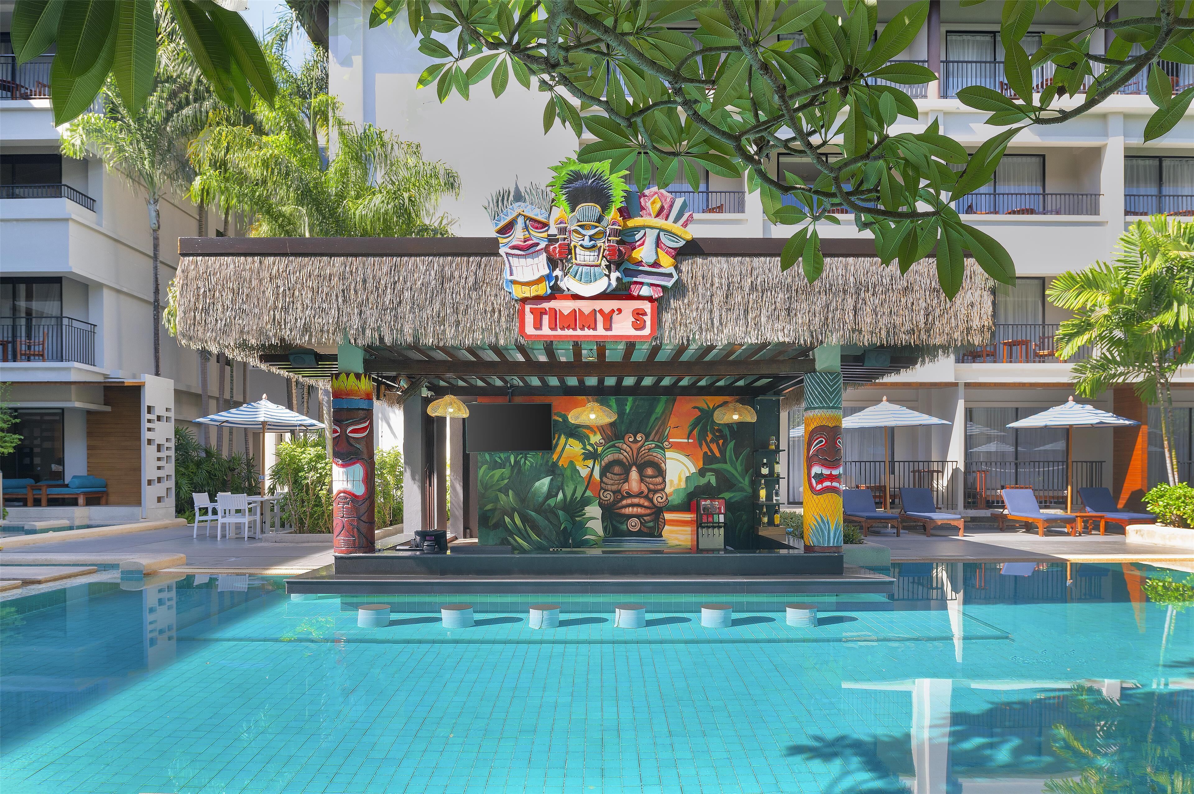 Um resort com piscina, bar tiki e área de estar externa.