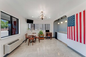 Uma cozinha moderna com área de refeições, uma janela grande e uma bandeira americana na parede.