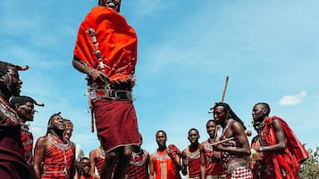 Um grupo de pessoas vestindo trajes típicos, ao ar livre sob um céu claro.