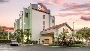 Um hotel Best Western Plus com design moderno, destacando uma entrada imponente e área de estacionamento.