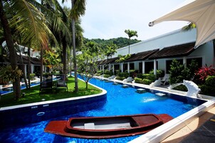 Piscina com barco, palmeiras e cadeiras de descanso.