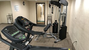 Ginásio com esteira, bicicleta ergométrica e aparelhos de musculação.