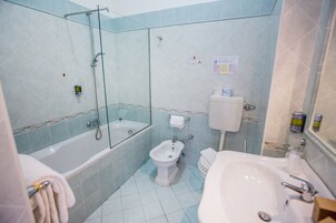 Casa de banho com banheira, bidé e lavatório.