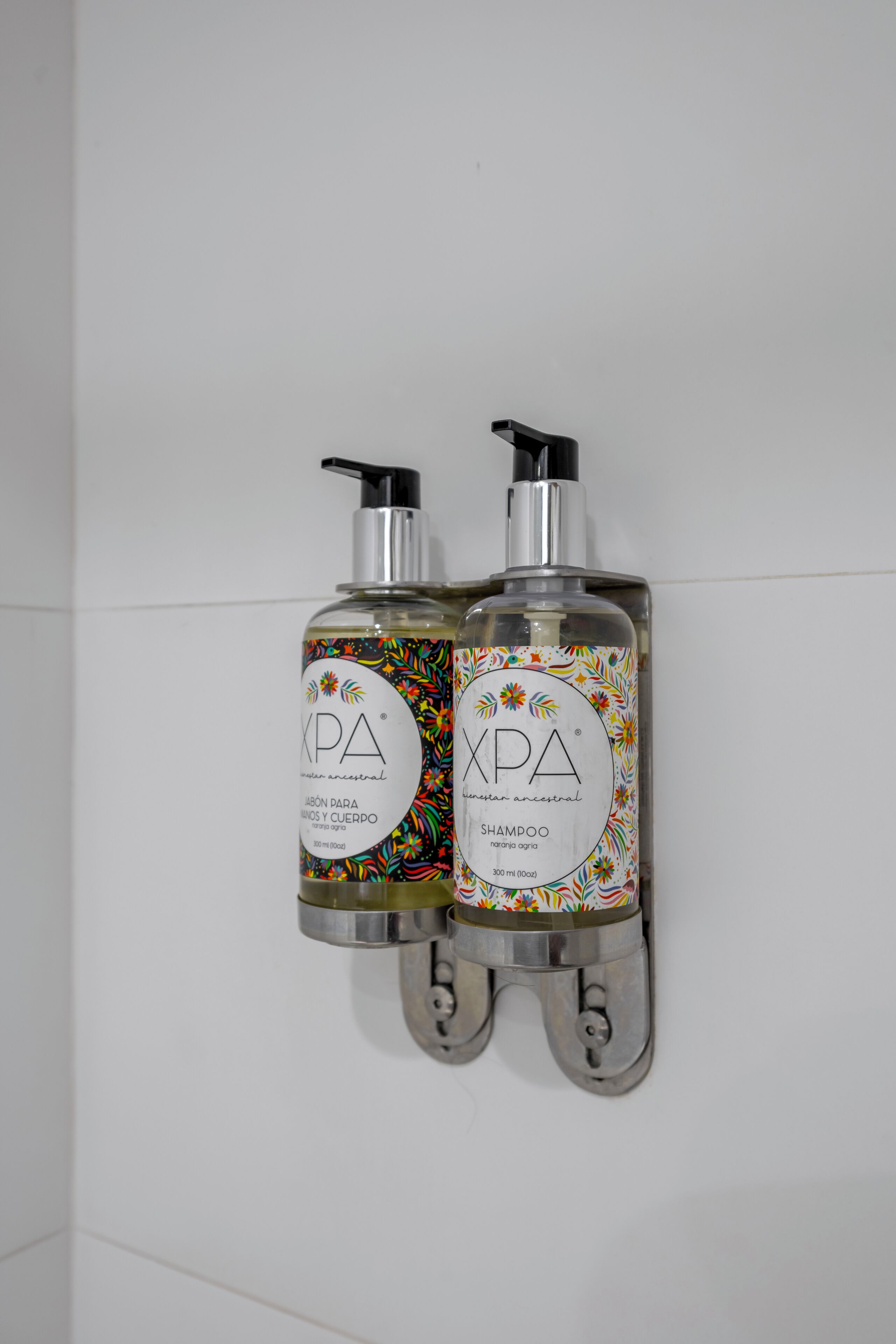 Duas embalagens de shampoo fixadas na parede.