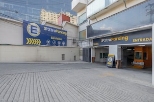 An empty parking lot with a building featuring signage for 'XtraParking' services.