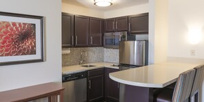 Um frigorífico/congelador grande, um micro-ondas, uma placa de cozinha