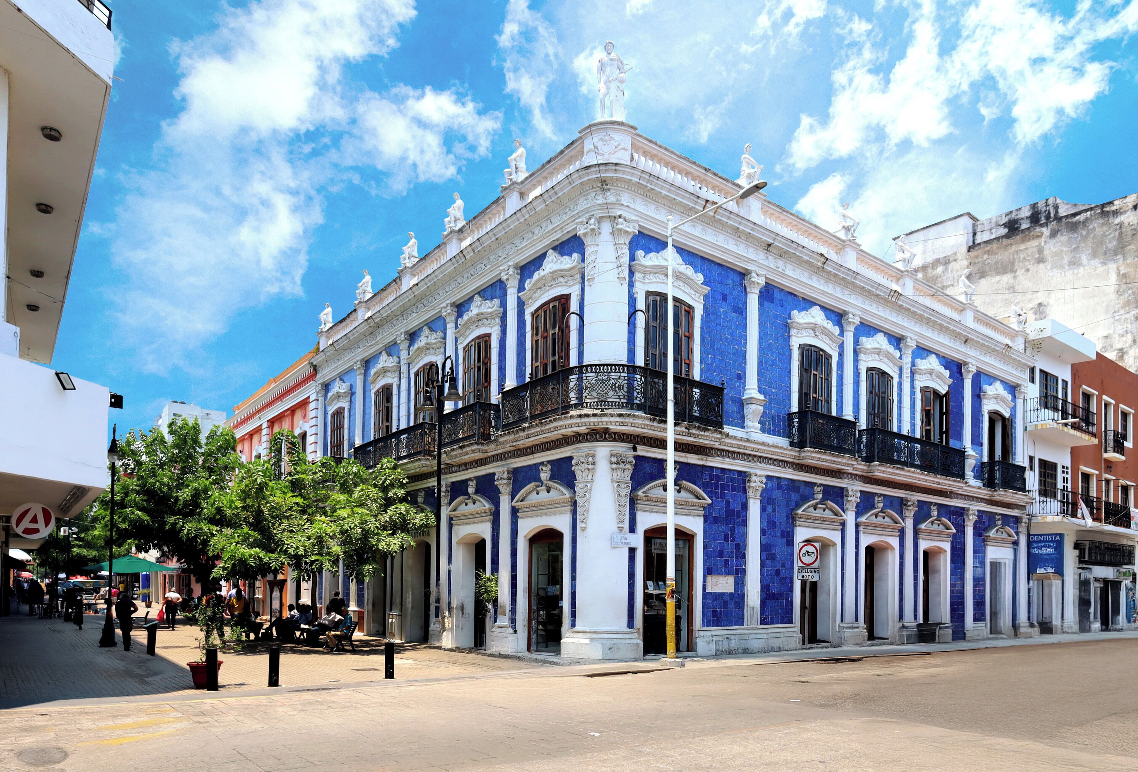 Um edifício histórico com arquitetura elaborada, uma varanda e vista para a rua.