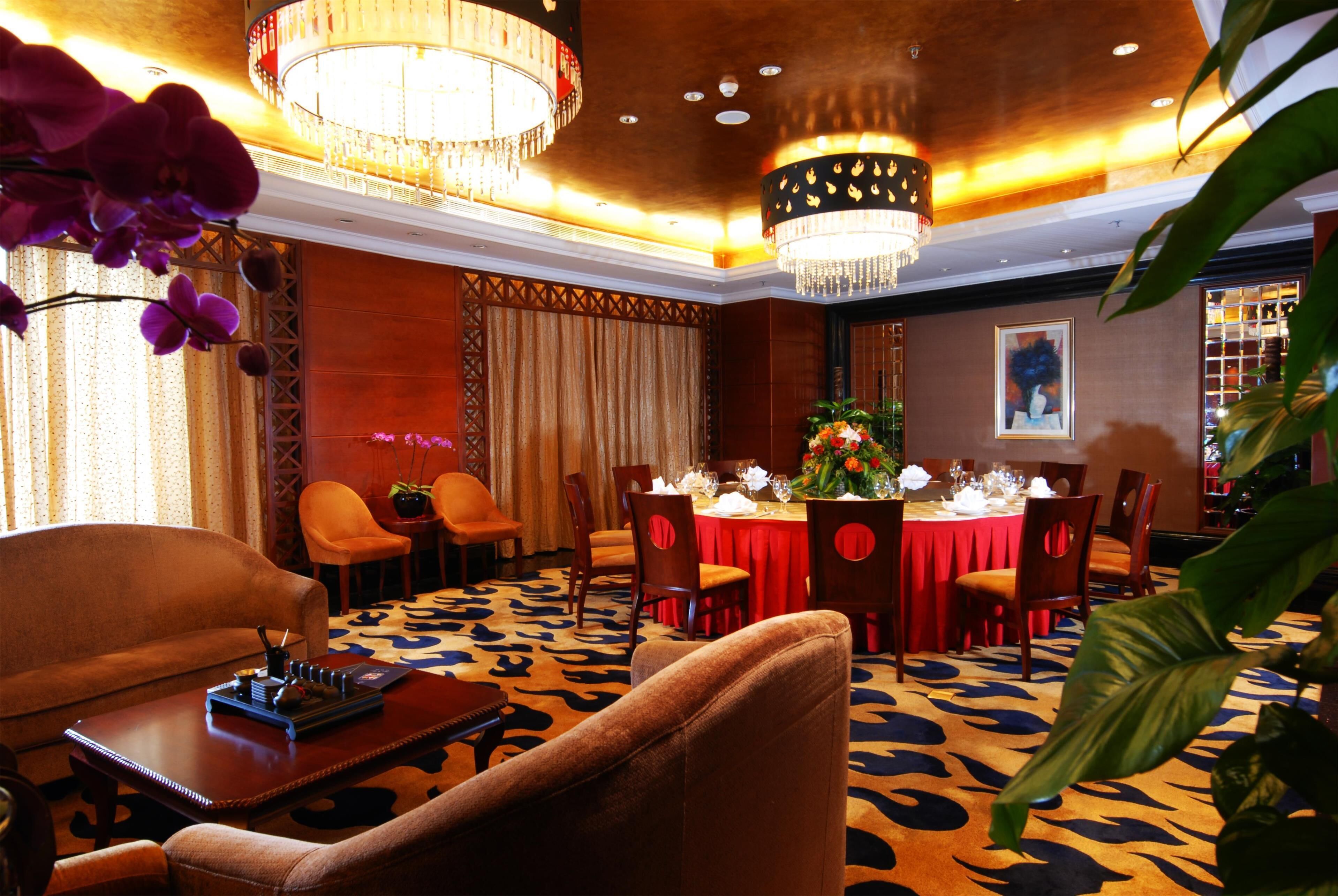 Uma sala de jantar com mesa redonda, cadeiras e lustre.