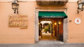 Entrada do Hotel Misión Catedral, com toldo verde, placa em formato de sino e placa com o número 37.