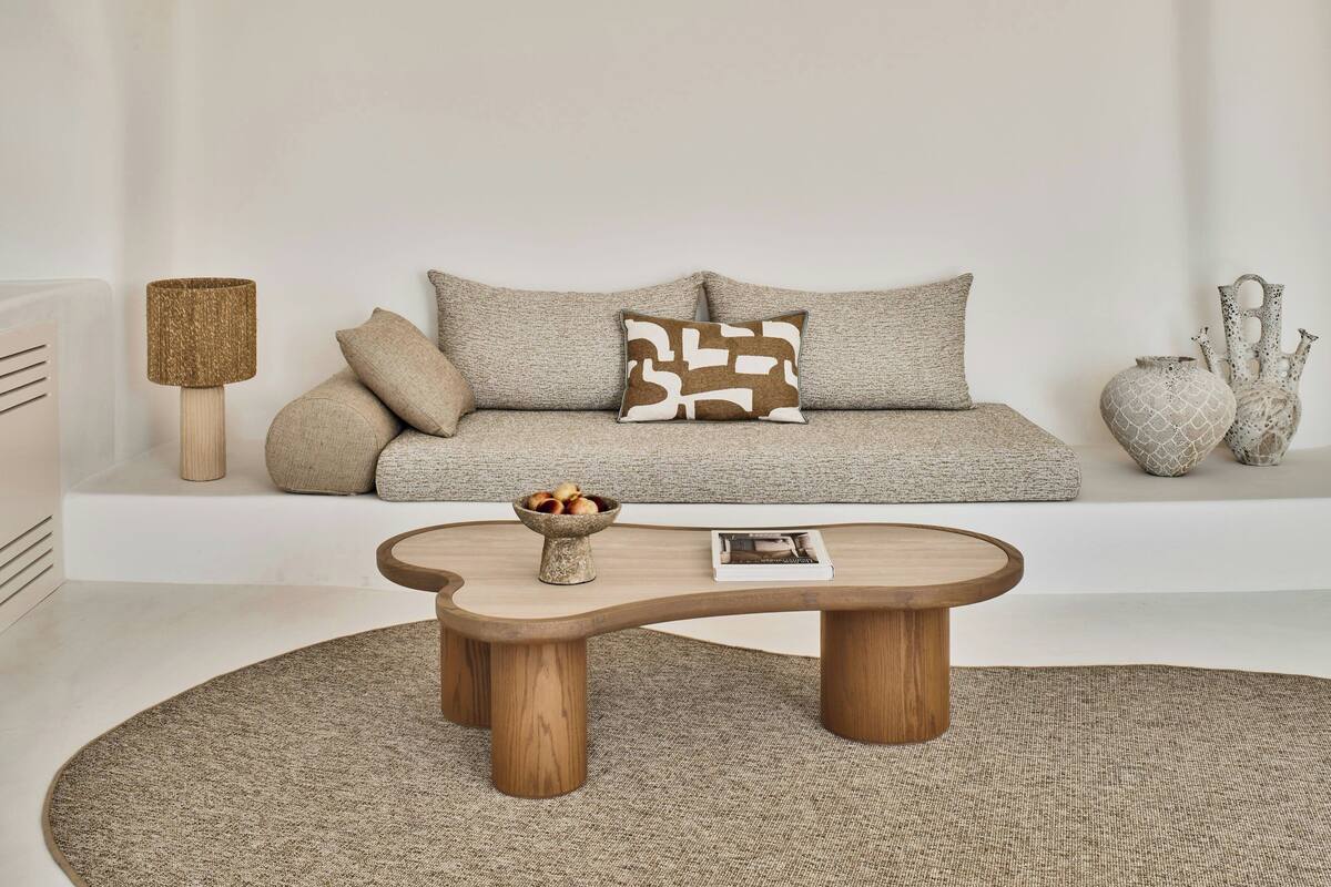 Uma sala de estar moderna com um sofá, uma mesa de centro de madeira e objetos decorativos.