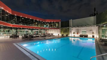 Piscina com espreguiçadeiras e área coberta com equipamentos de ginástica.