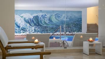 Interior moderno com um grande mural de onda do mar, piscina e áreas de estar com velas.