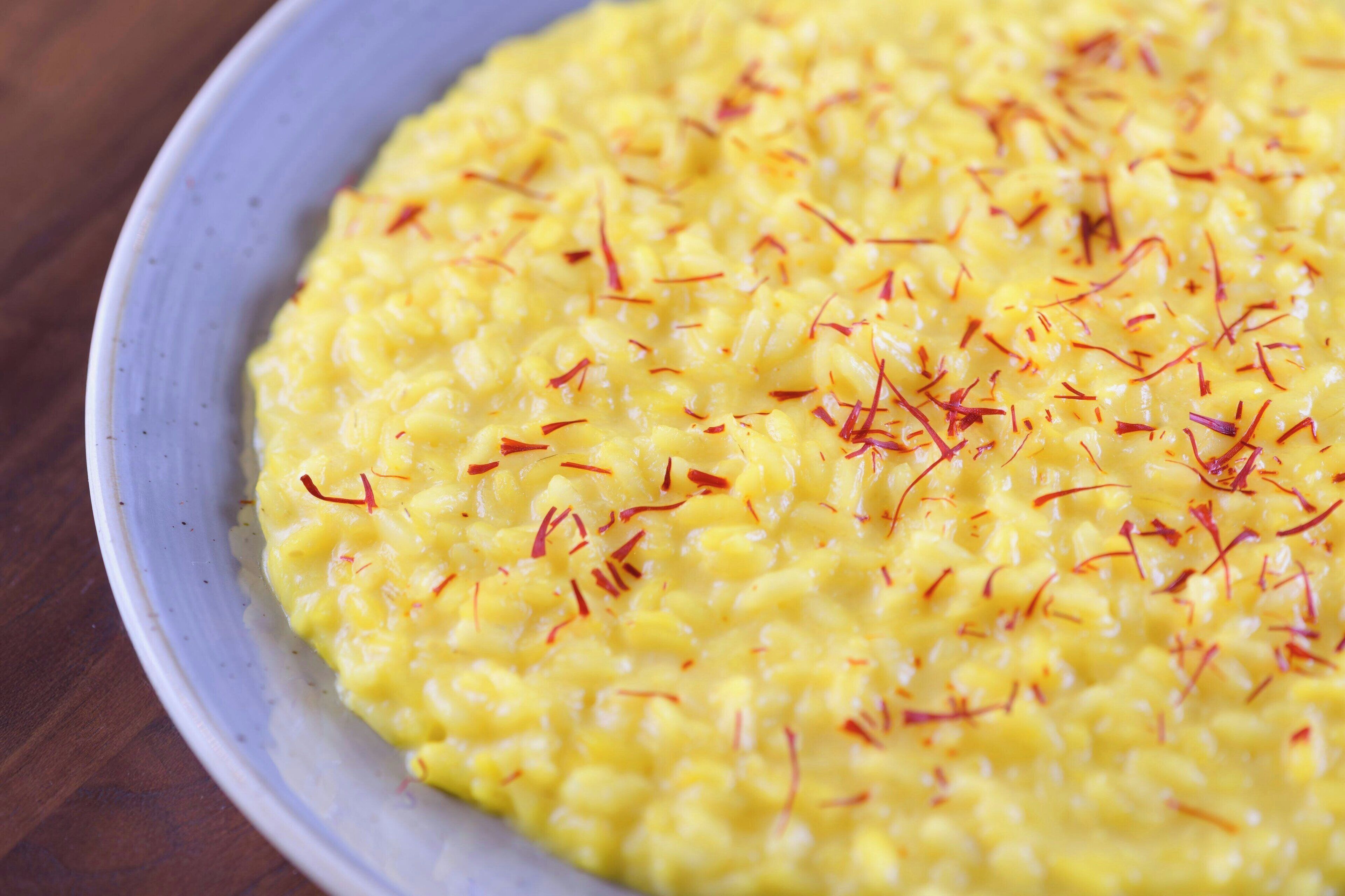 Close-up de um prato com arroz amarelo decorado com especiarias vermelhas.