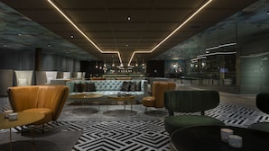 Uma área de estar moderna com um sofá central, poltronas e uma mesa de centro.