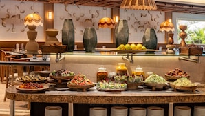Um buffet com diversos alimentos e vasos decorativos.