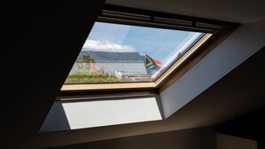 Um claraboia com vista para uma montanha e uma bandeira.