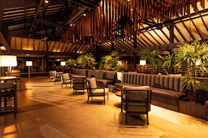 Decoração moderna com áreas de estar, mesas e iluminação ambiente.