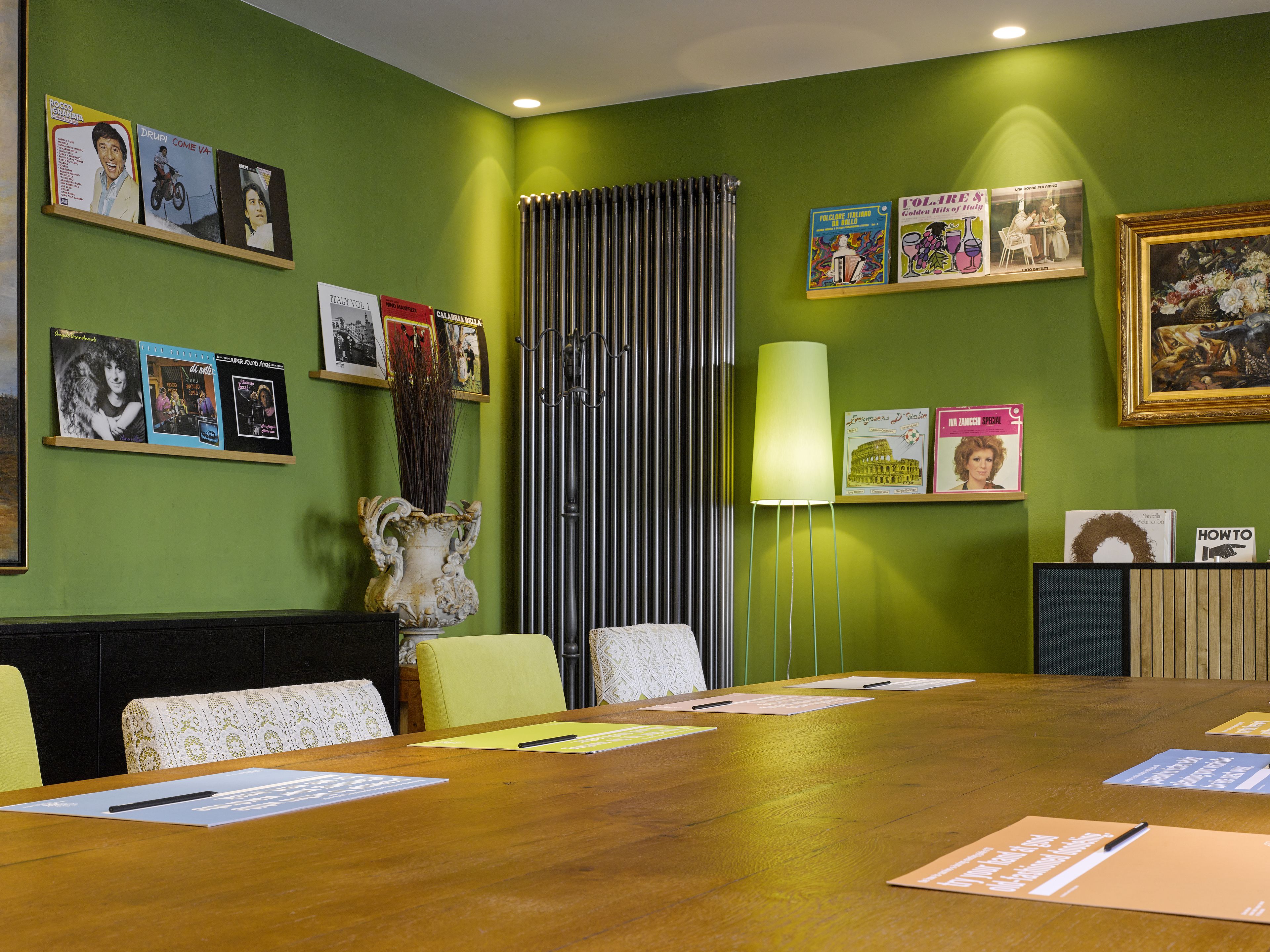 Uma sala de conferências com uma mesa comprida, cadeiras e diversos objetos emoldurados nas paredes.